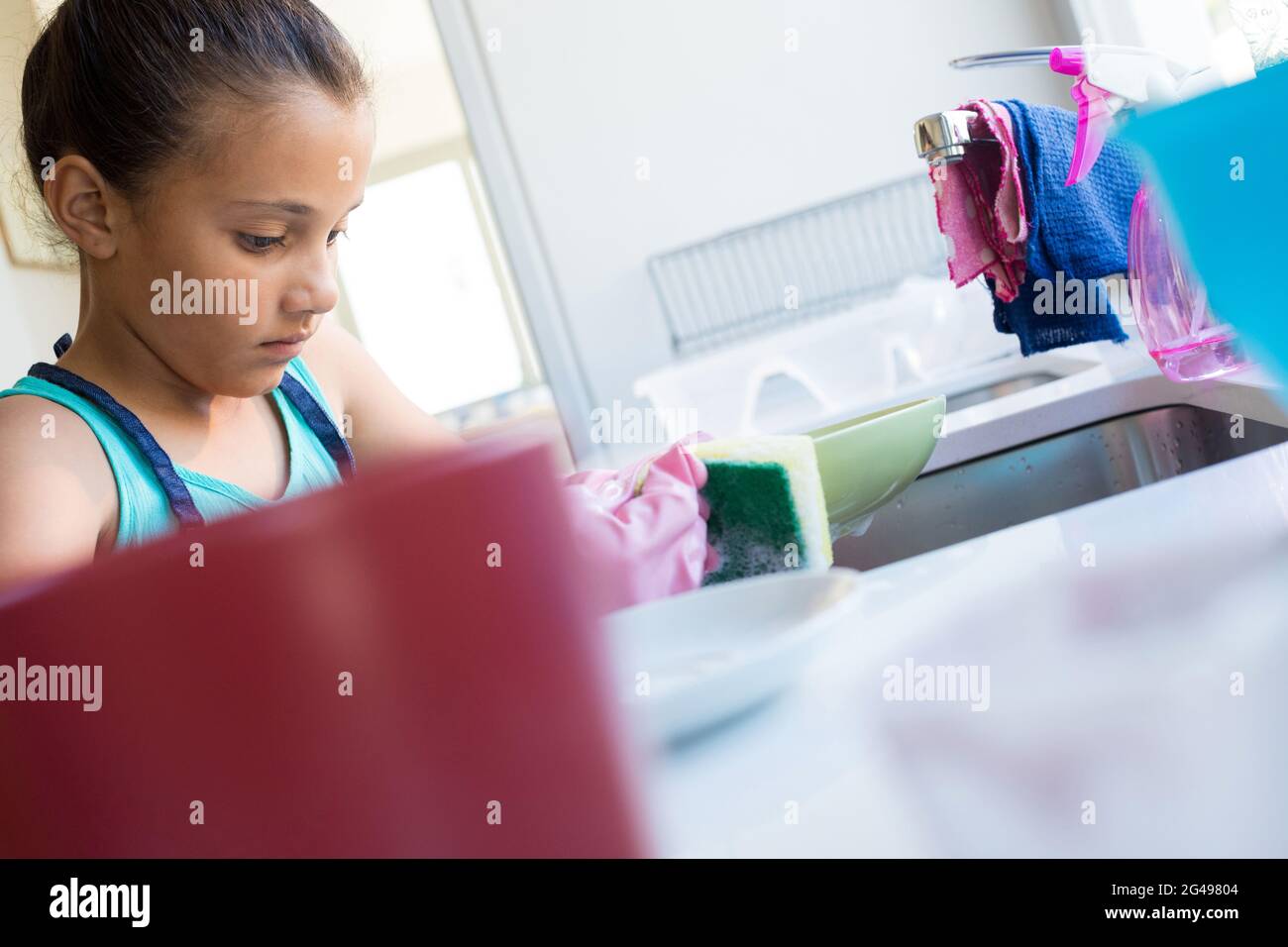 Cute little girl washing plate in kitchen sink Stock Photo - Alamy