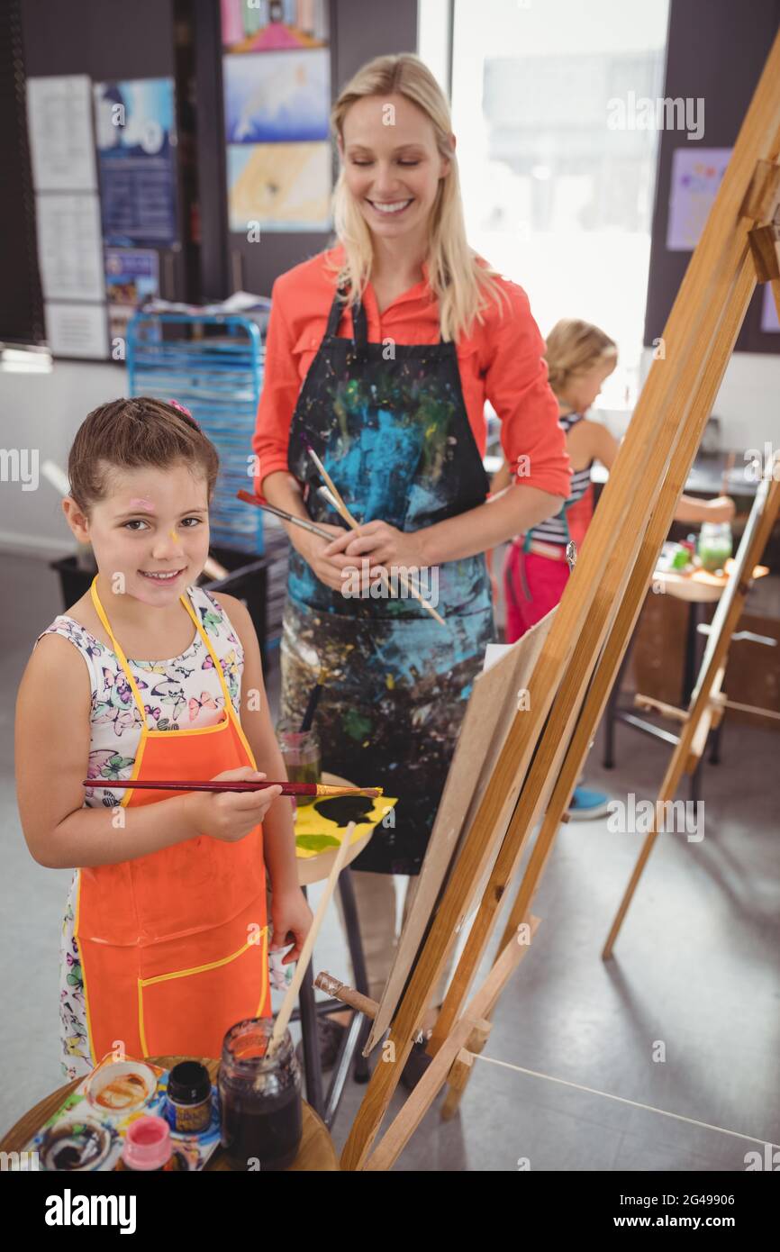 Teacher assisting girl in drawing class Stock Photo - Alamy
