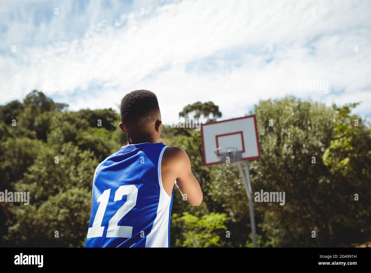 Rear view of teenage boy practicing basketball Stock Photo - Alamy