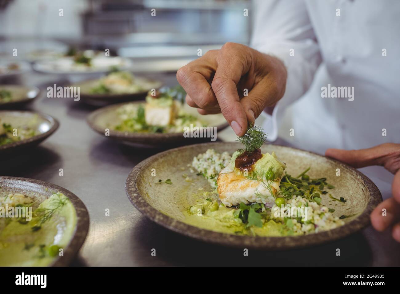 Mid section of male chef garnishing appetizer in plate Stock Photo - Alamy