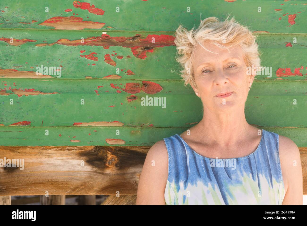 Close up of senior woman looking away while standing against wall Stock ...