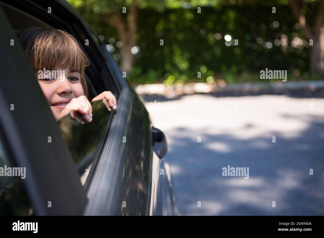 Teenage girl looking through car window Stock Photo - Alamy
