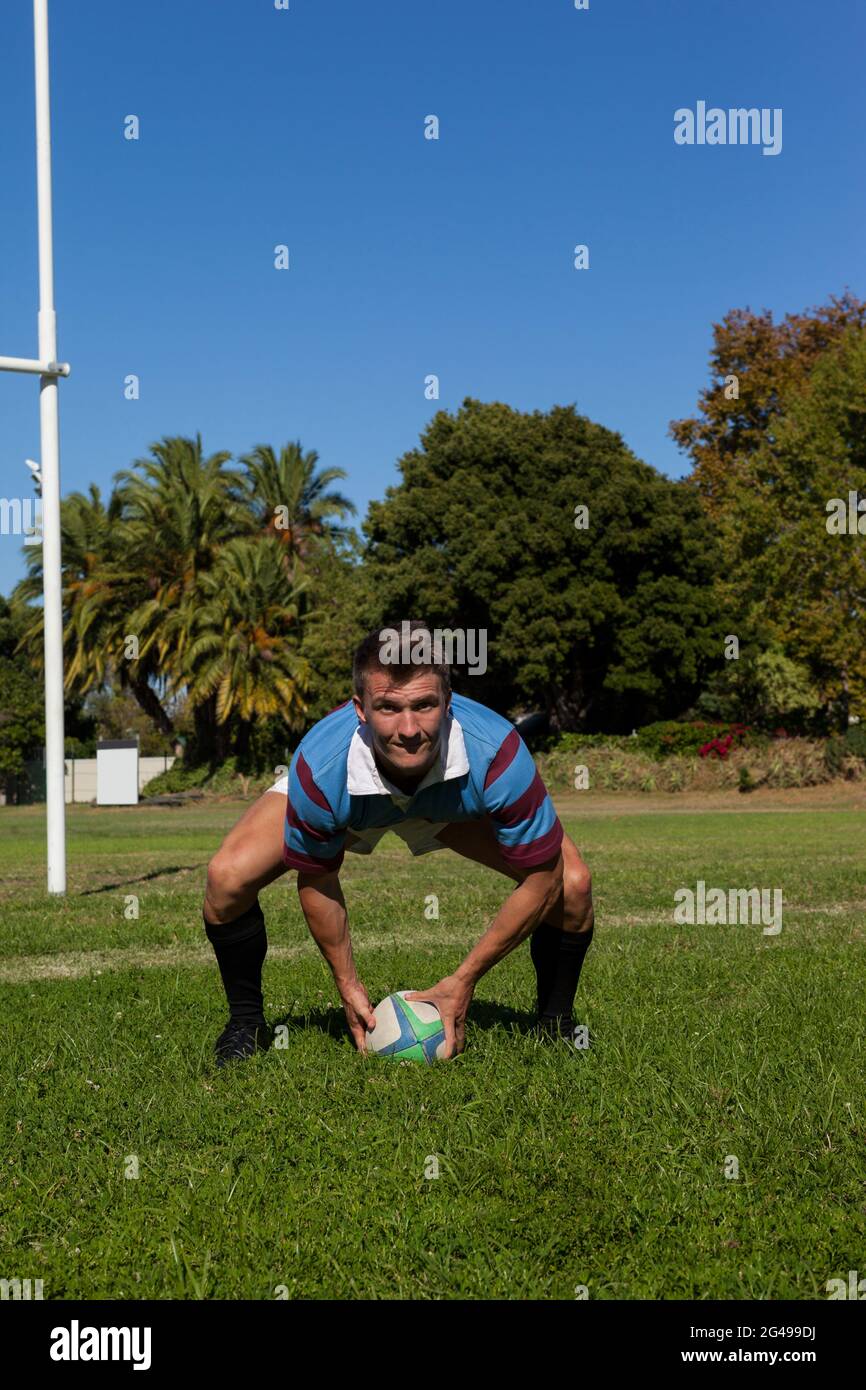 Portrait of rugby player crouching on field Stock Photo - Alamy