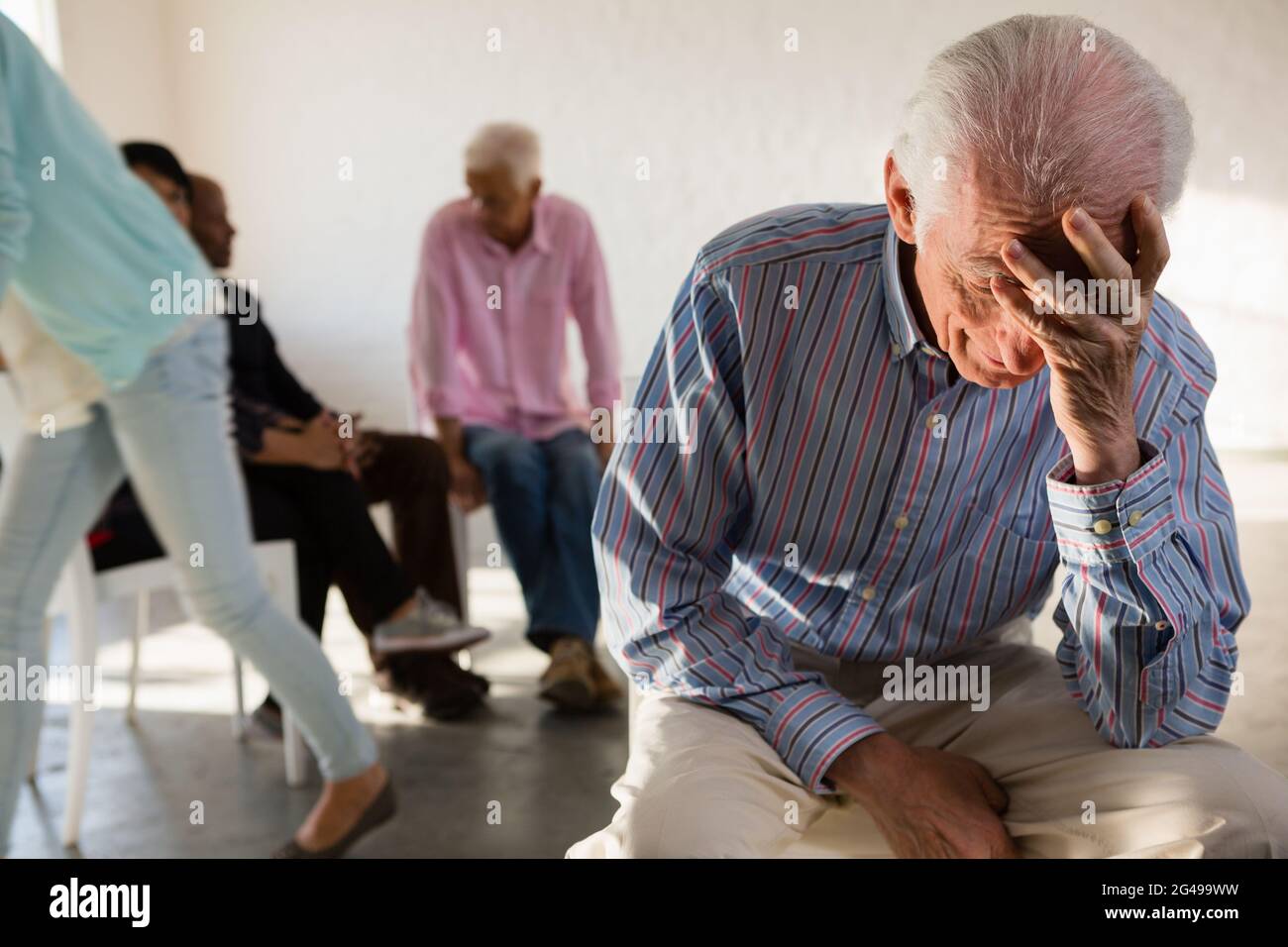 Tensed senior man with friends in background Stock Photo - Alamy