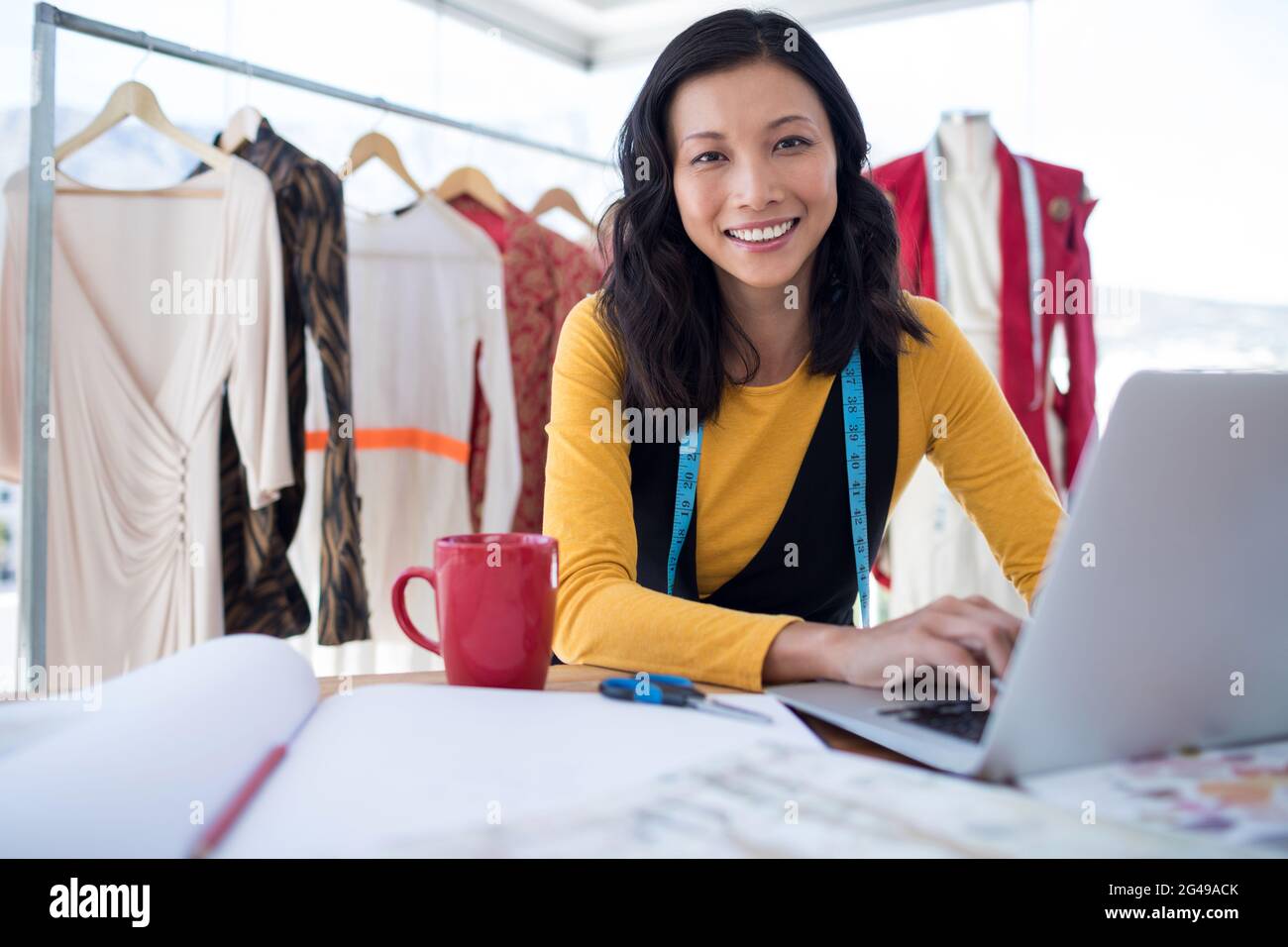 Female designer using laptop Stock Photo - Alamy