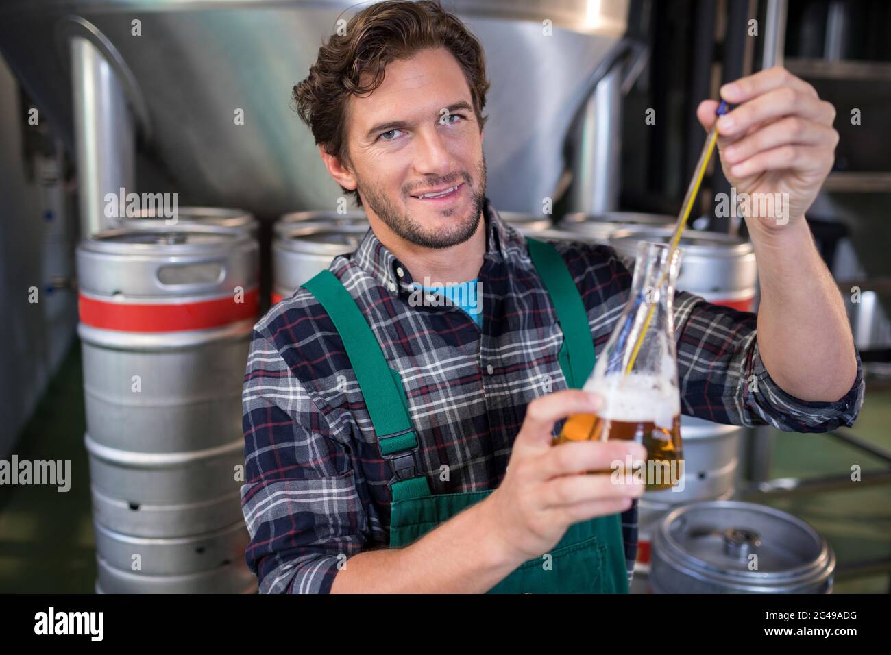 Portrait of smiling worker examining beer at factory Stock Photo - Alamy