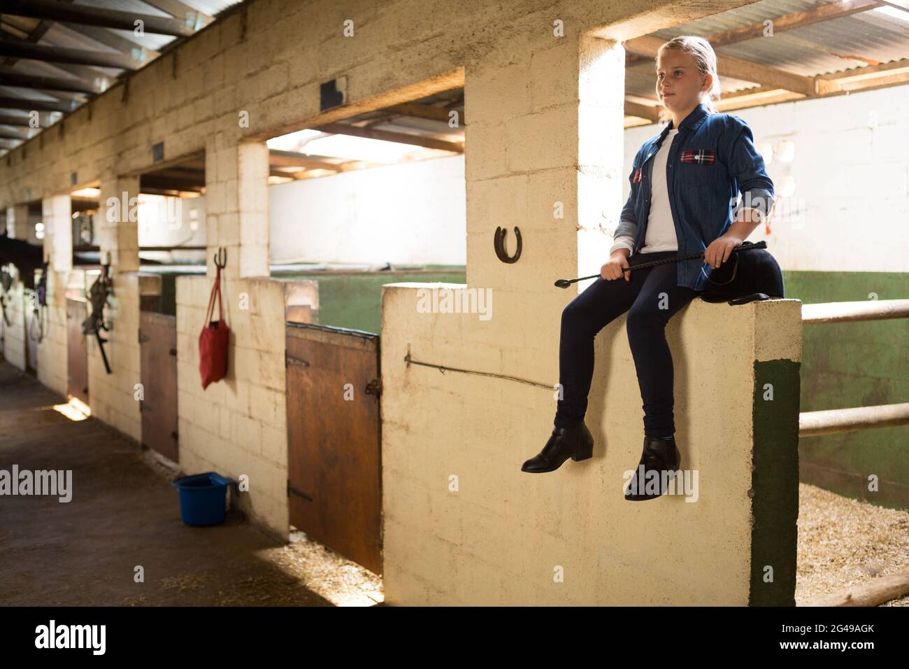 Girl sitting in stable Stock Photo - Alamy