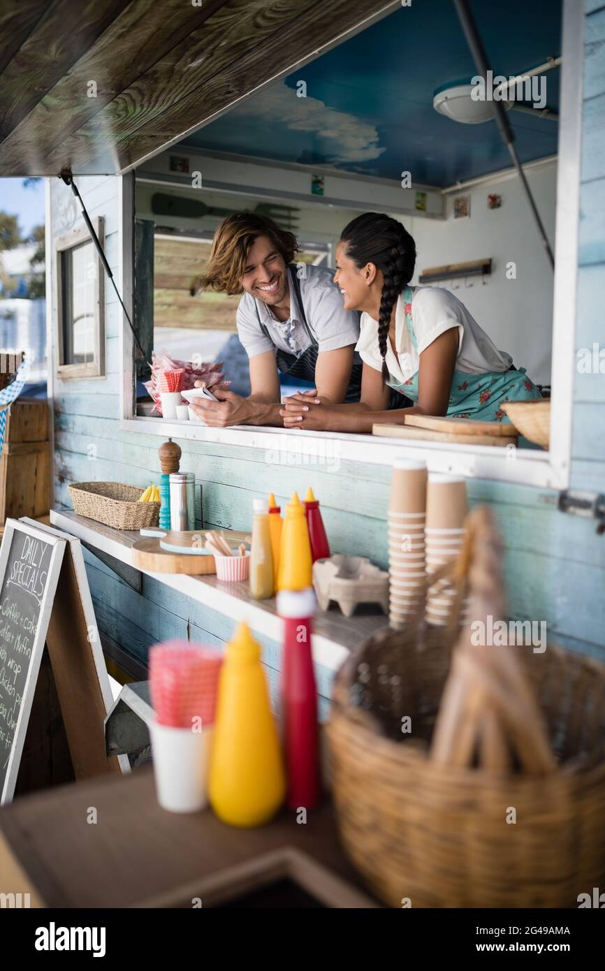 Waiter and waitress interacting with each other at counter Stock Photo ...