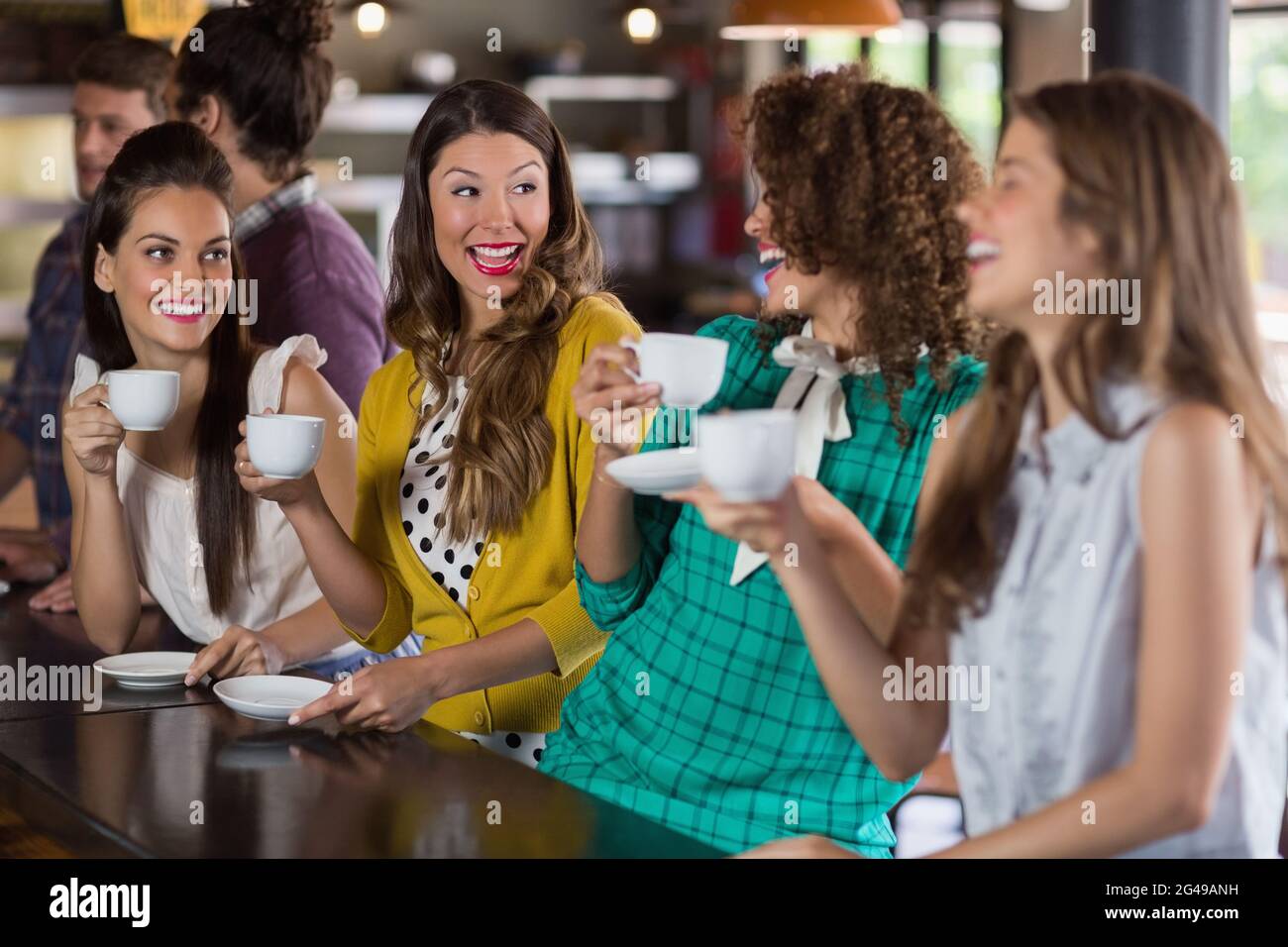 Friends talking while drinking coffee in cafe Stock Photo - Alamy