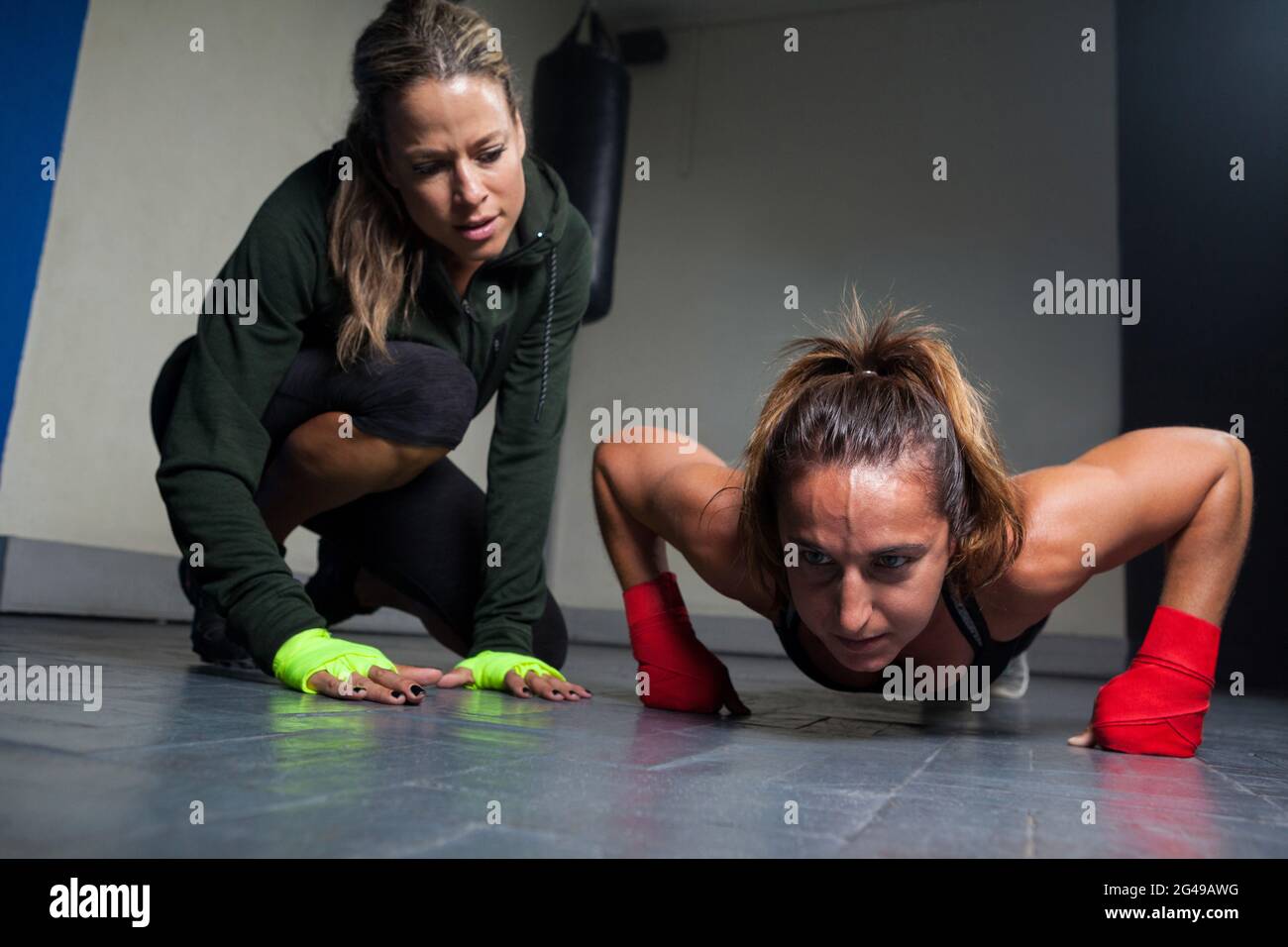 Trainer assisting woman in exercise Stock Photo - Alamy