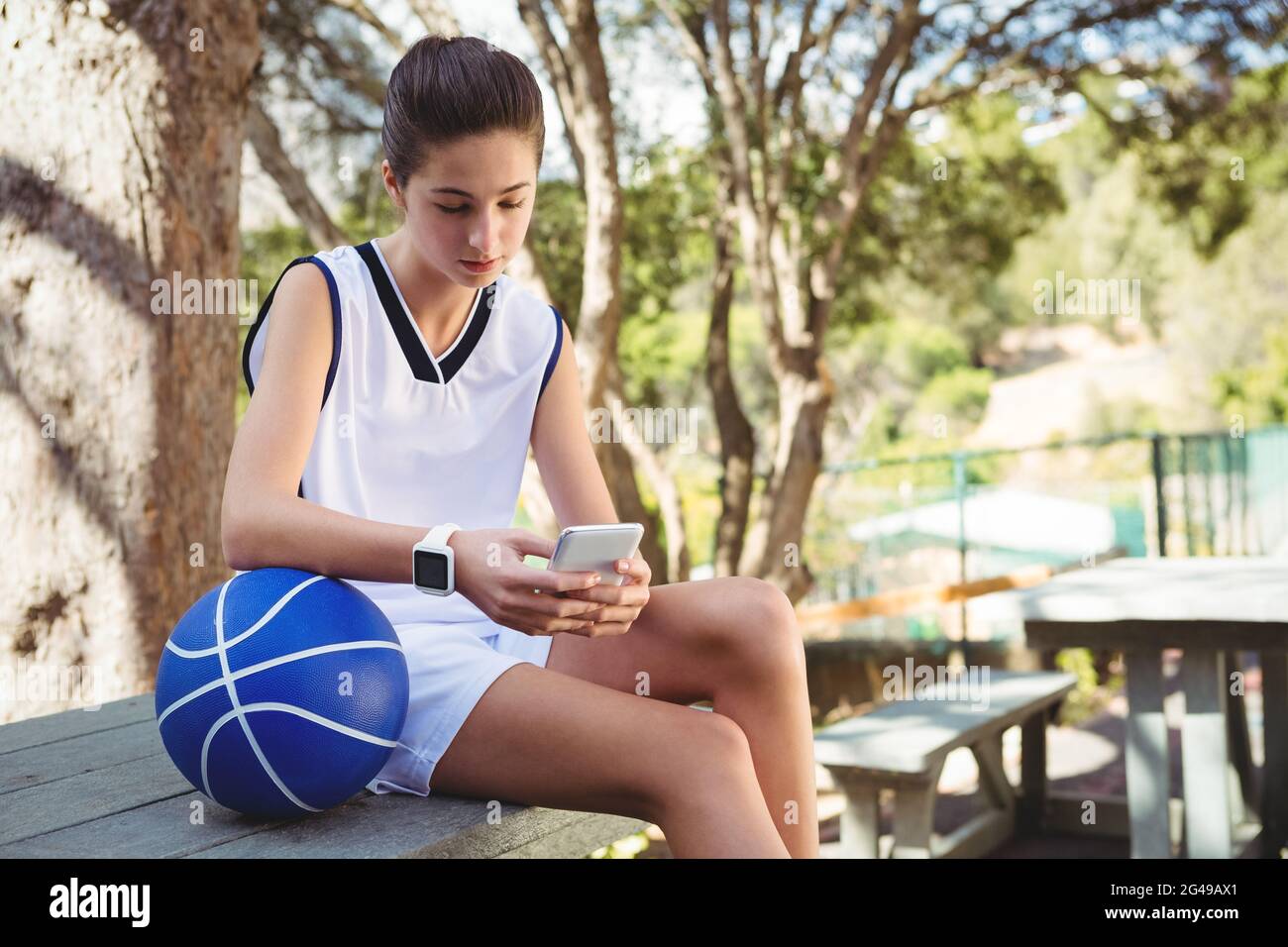 Female basketball player using mobile phone Stock Photo - Alamy