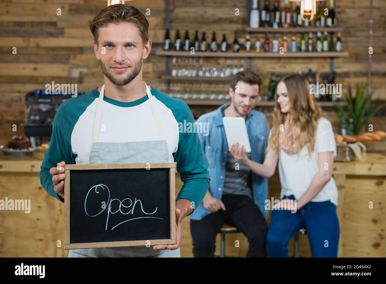 Male waiter standing open sign hi-res stock photography and images - Alamy