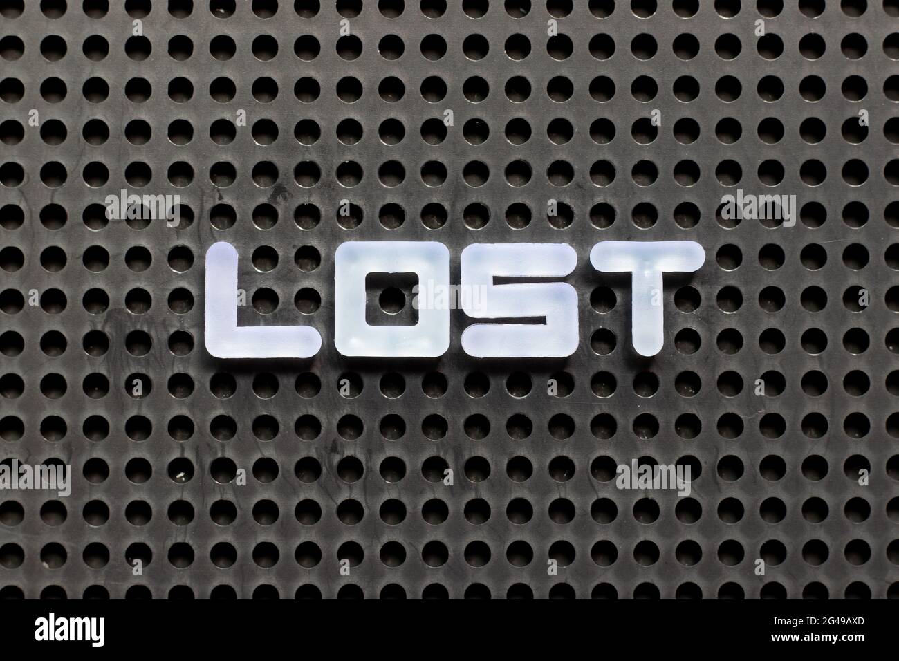 White color letter in word lost on black pegboard background Stock ...
