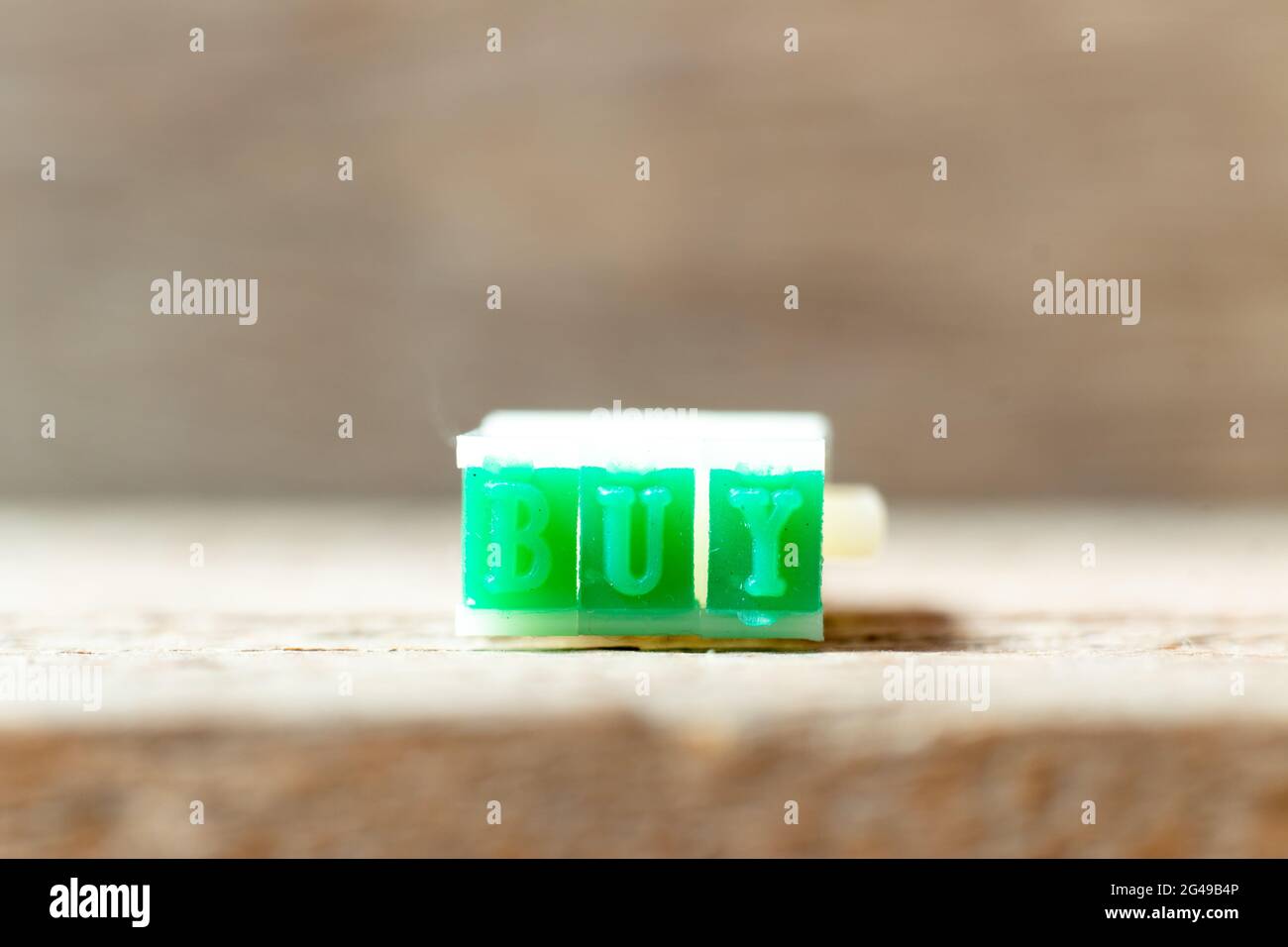 Green color rubber stamp in word buy on wood background Stock Photo - Alamy