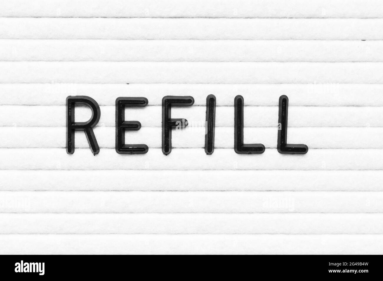 Black alphabet letter in word refill on white felt board background ...