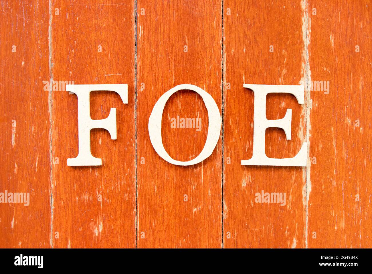 Alphabet letter in word foe on old red color wood plate background ...