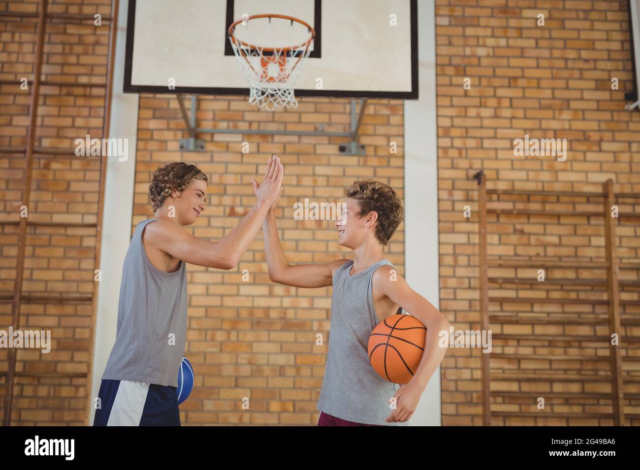 High school boys with basketball giving a high five Stock Photo - Alamy