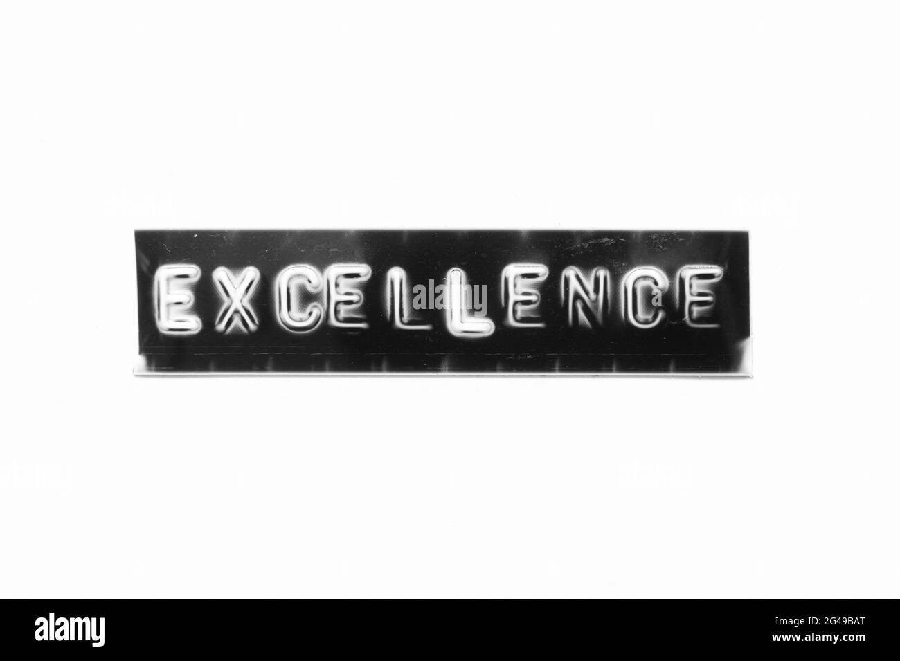 Embossed letter with word excellence in black banner on white paper ...