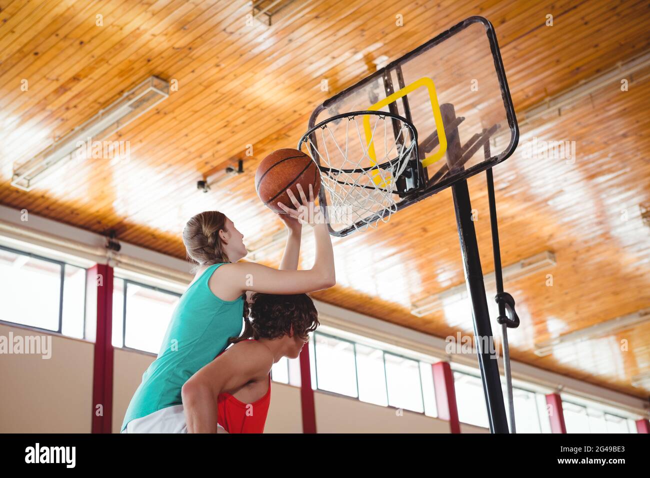 Man assisting female friend while playing basketball Stock Photo - Alamy