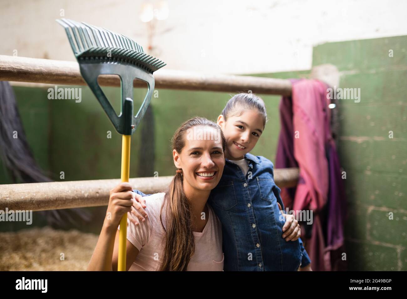 Portrait of female jockey holding rake with sister Stock Photo - Alamy