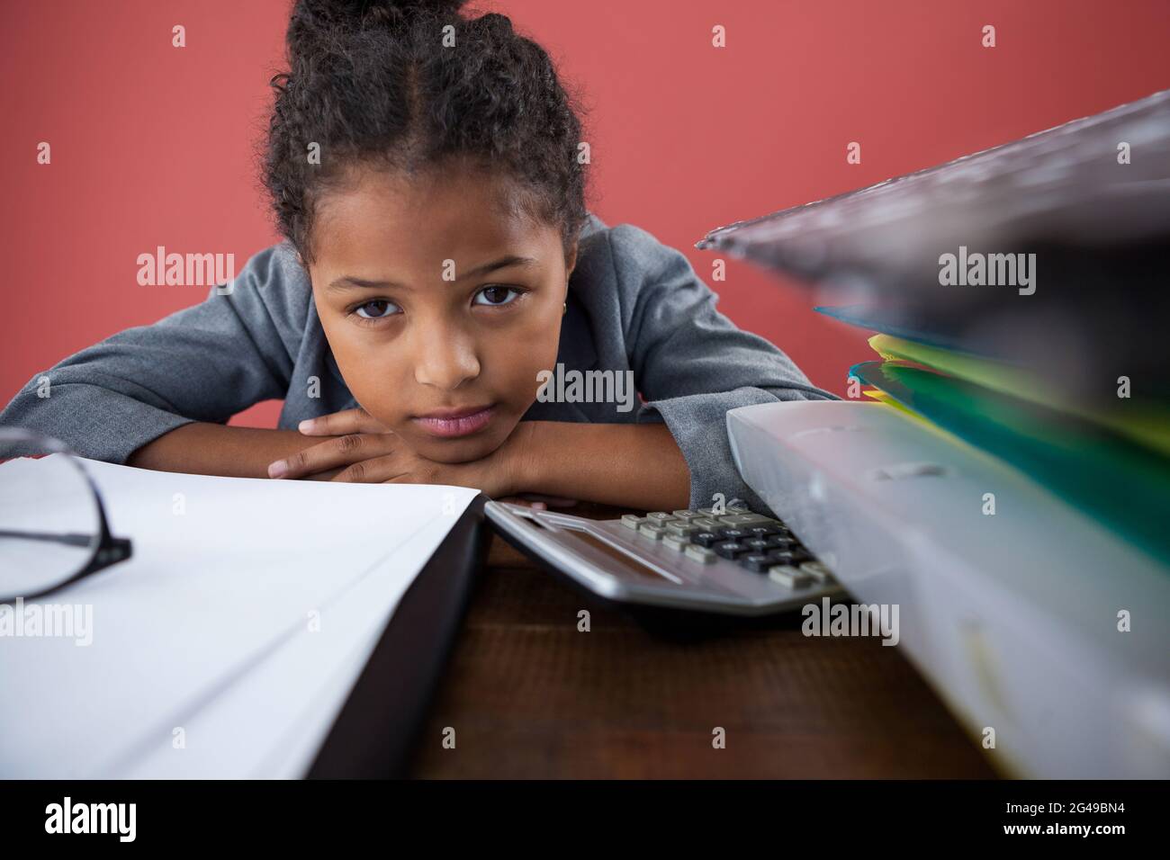 Close up portrait of girl pretending as businesswoman leaning on desk ...