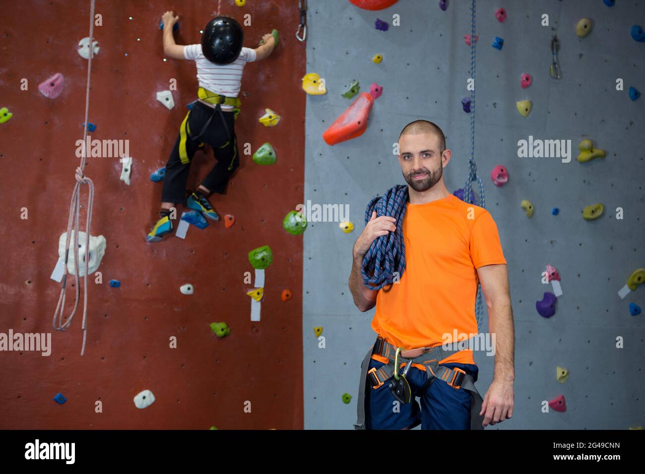 Trainer standing with rope in fitness studio Stock Photo - Alamy