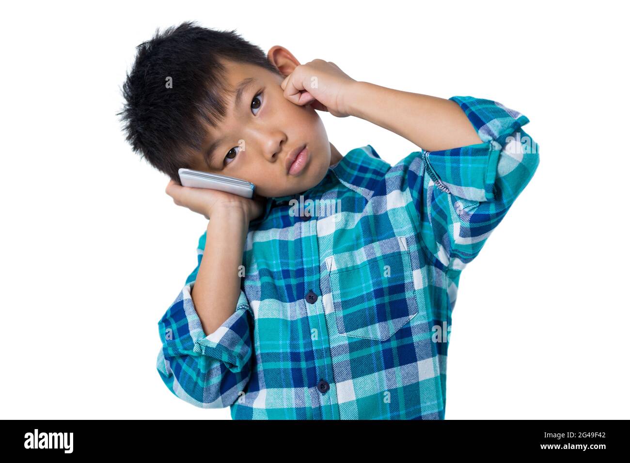 Boy talking on mobile phone against white background Stock Photo - Alamy