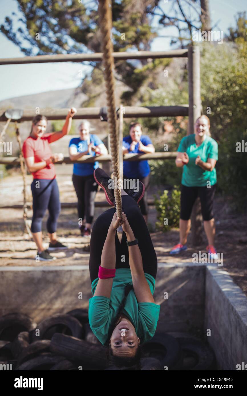 Fit woman climbing a rope during obstacle course training Stock Photo ...