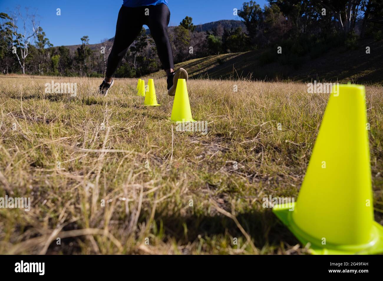 Low-section of woman running through training cones Stock Photo - Alamy