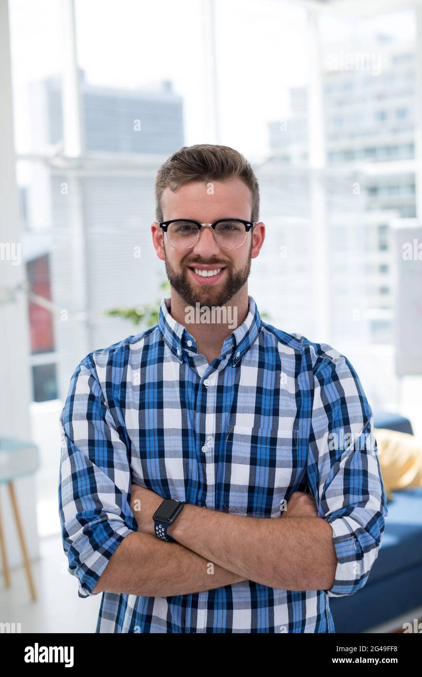 Male executive standing with arms crossed in office Stock Photo - Alamy