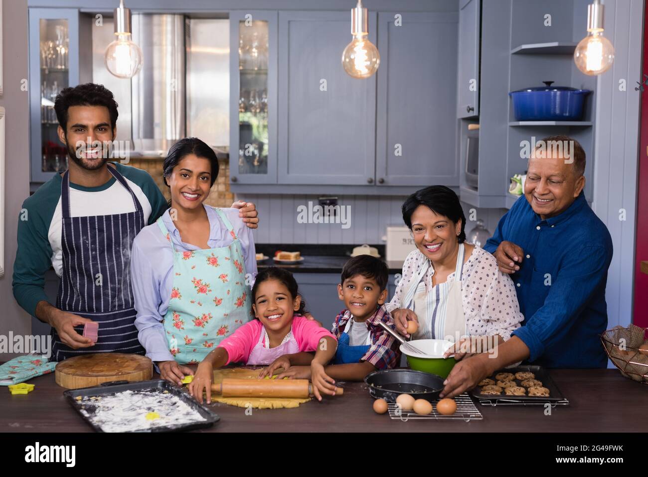 Portrait of multi-generation family smiling together while preparing ...