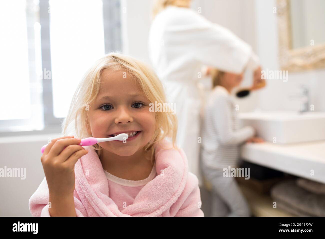 Girl brushing teeth in bathroom Stock Photo - Alamy