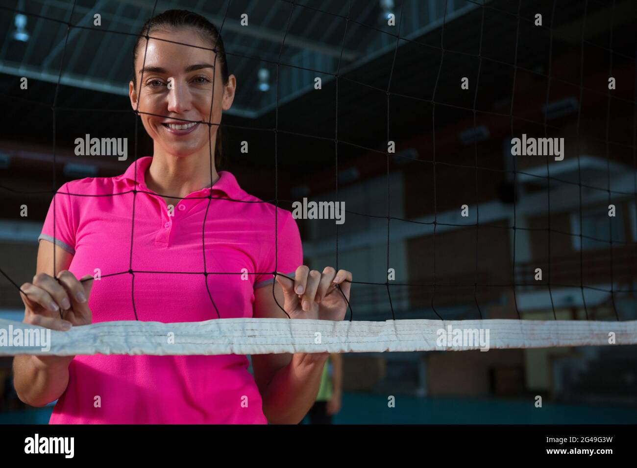 Portrait of female volleyball player behind net Stock Photo - Alamy