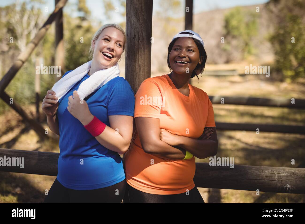 Happy friends standing with arms crossed during obstacle course Stock ...