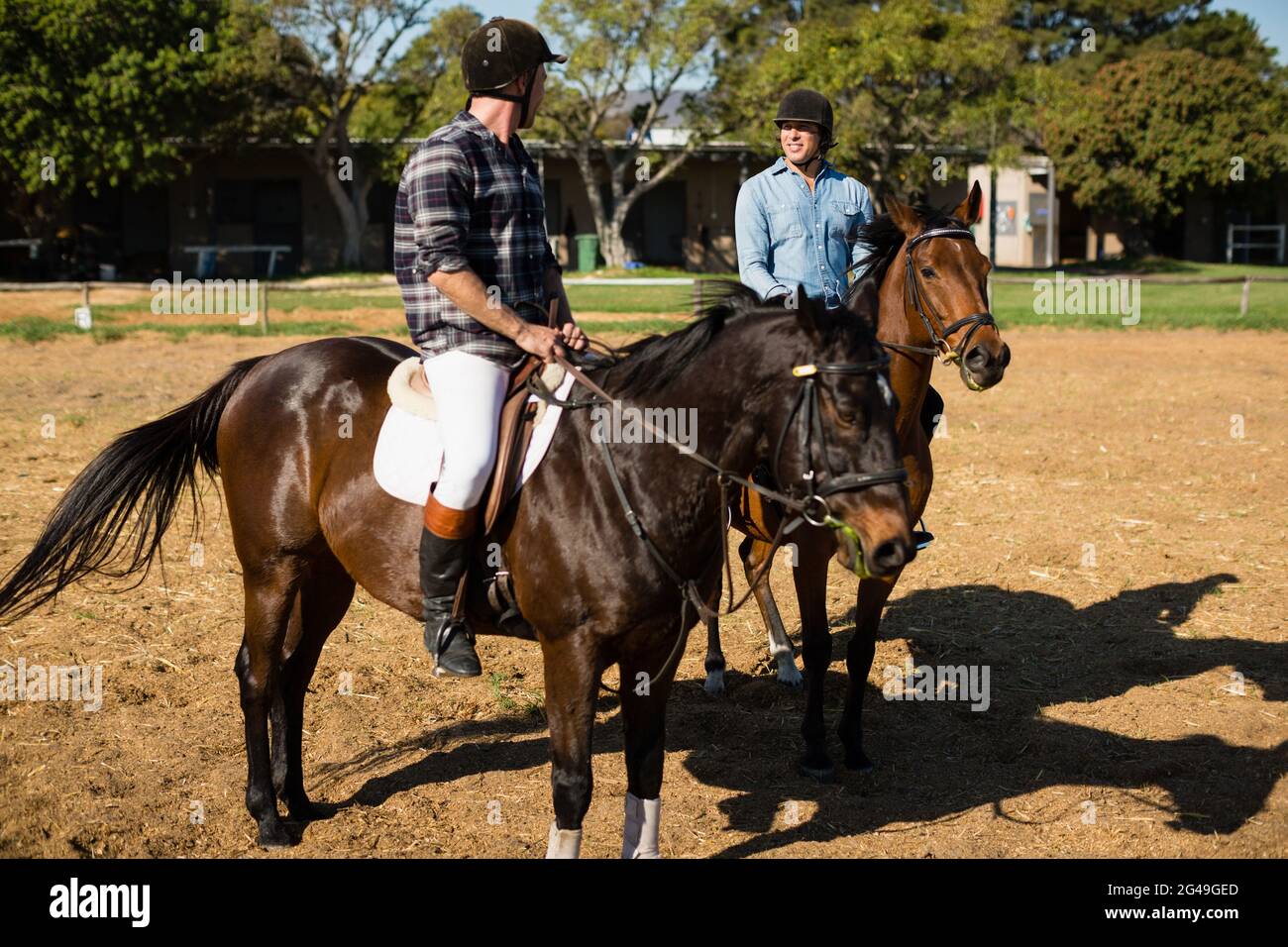 Two male friends riding horse in the ranch Stock Photo - Alamy