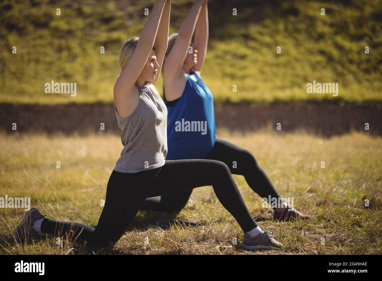 Beautiful women praising yoga during obstacle course Stock Photo - Alamy