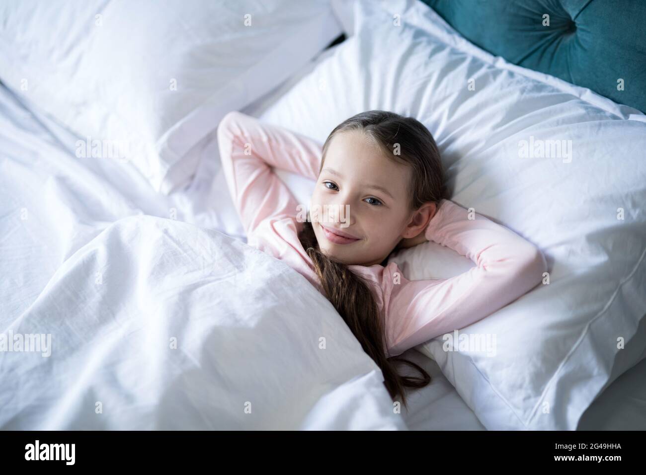 Smiling girl lying on bed in bedroom Stock Photo - Alamy