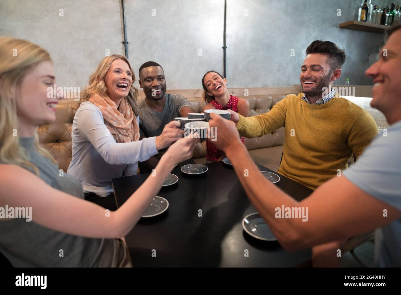 Happy friends toasting coffee Stock Photo - Alamy