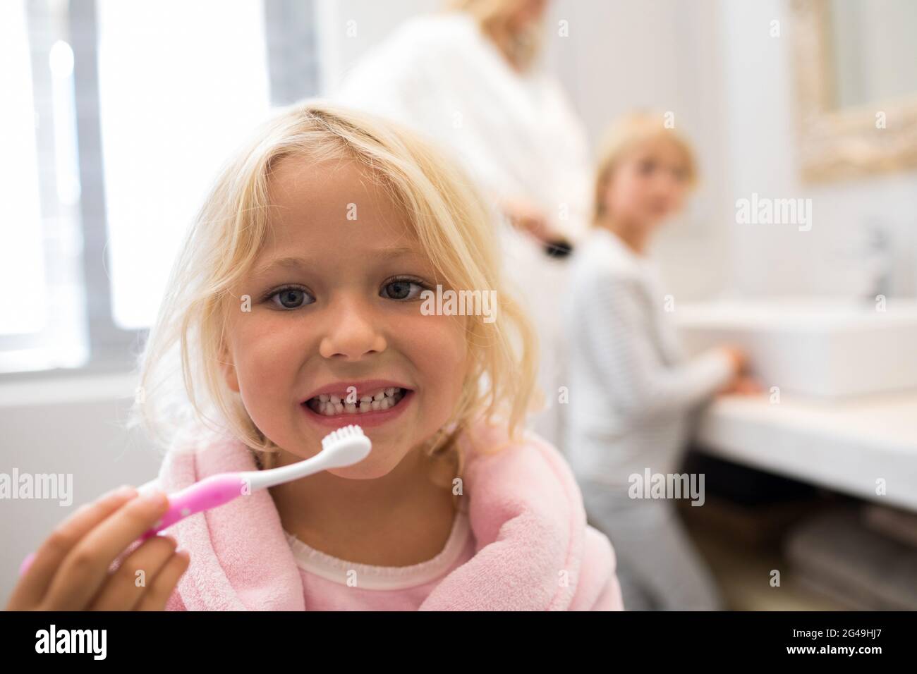 Girl brushing teeth in bathroom Stock Photo - Alamy
