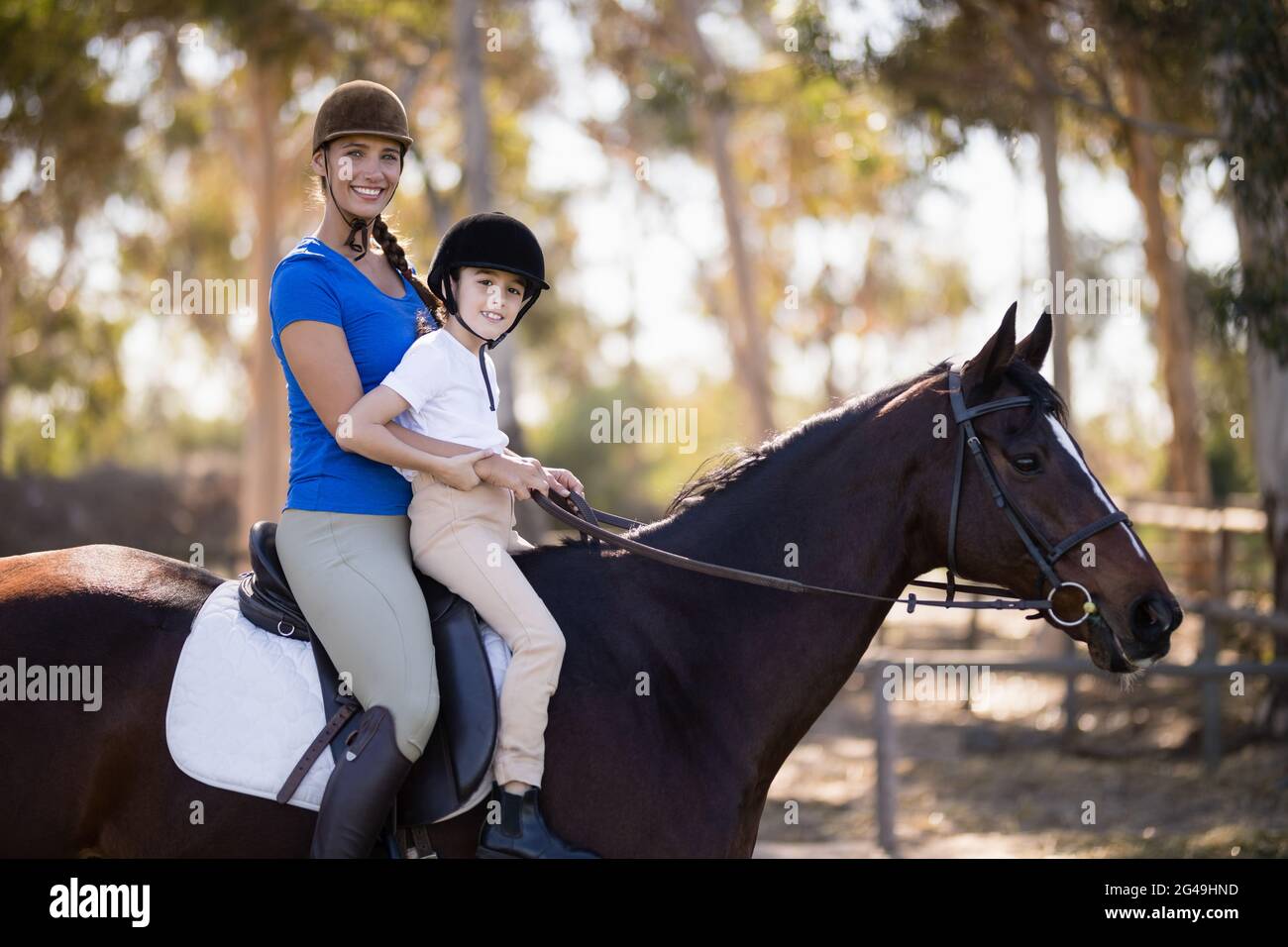 Portrait of Female jockey and girl sitting horseback riding Stock Photo ...