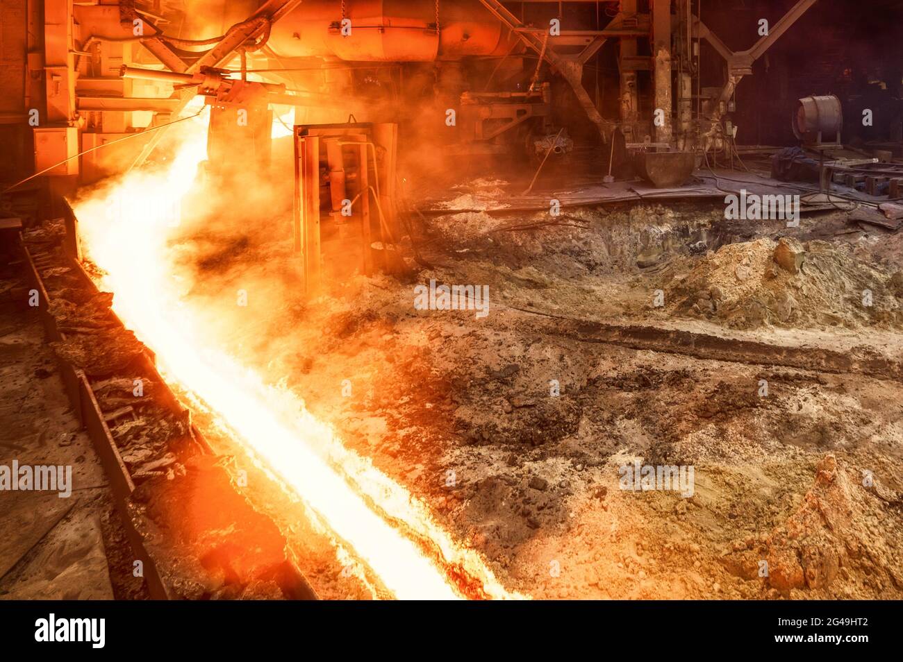 A stream of hot metal, molten steel flowing along a guide chute Stock ...