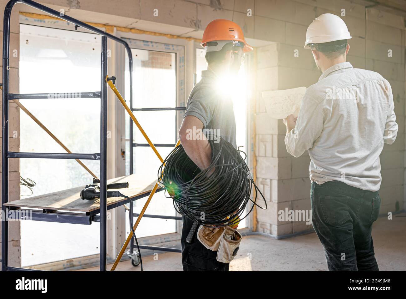 Two builder engineers talking at building site, engineer explaining a ...