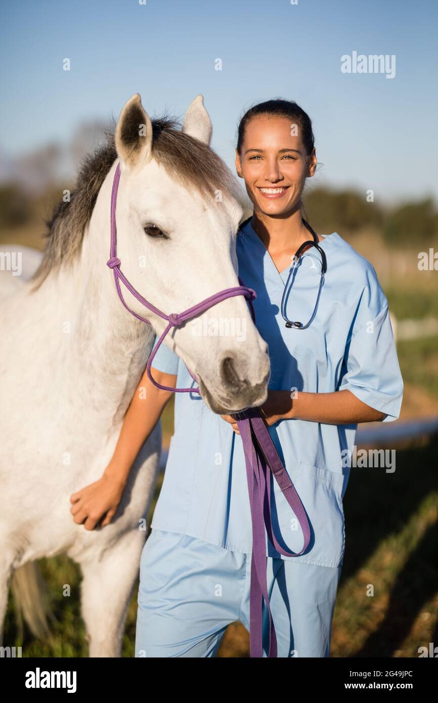 Portrait smiling female vet by horse Stock Photo - Alamy