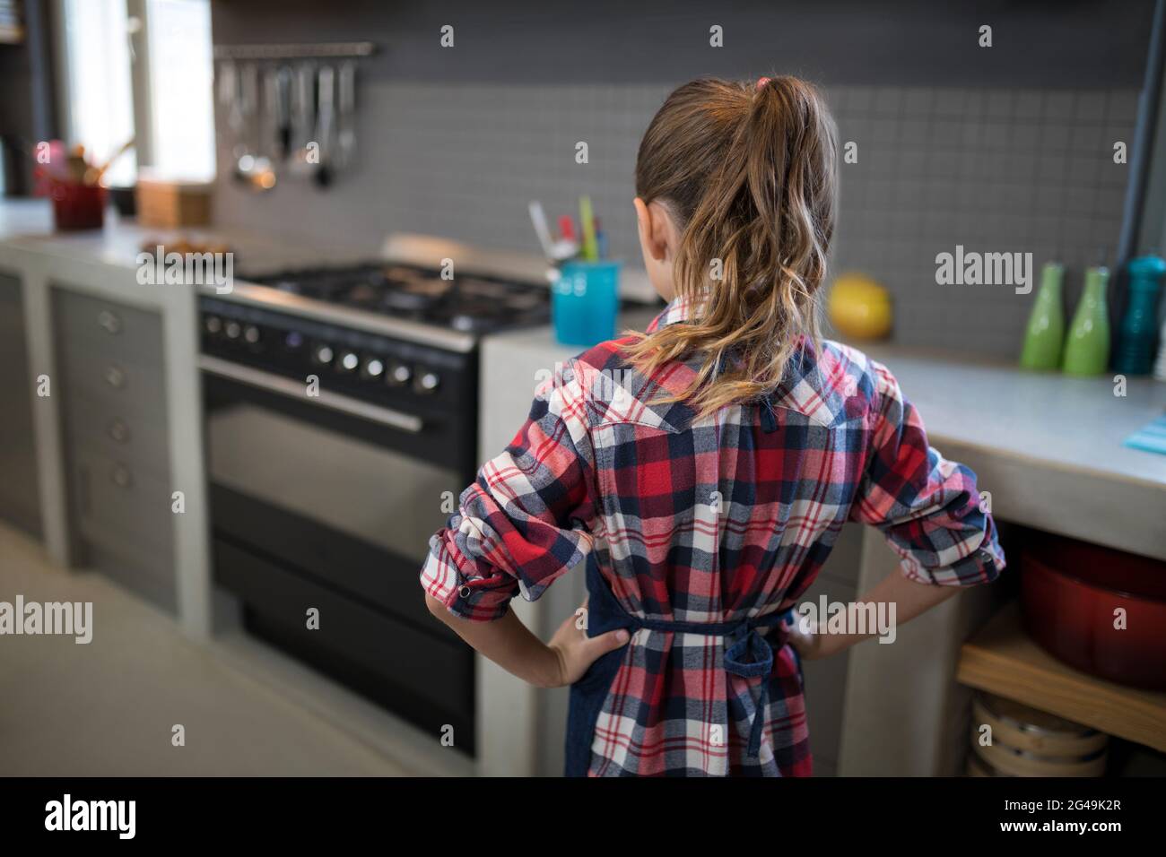 Smiling girl posing wearing an apron in the kitchen Stock Photo - Alamy