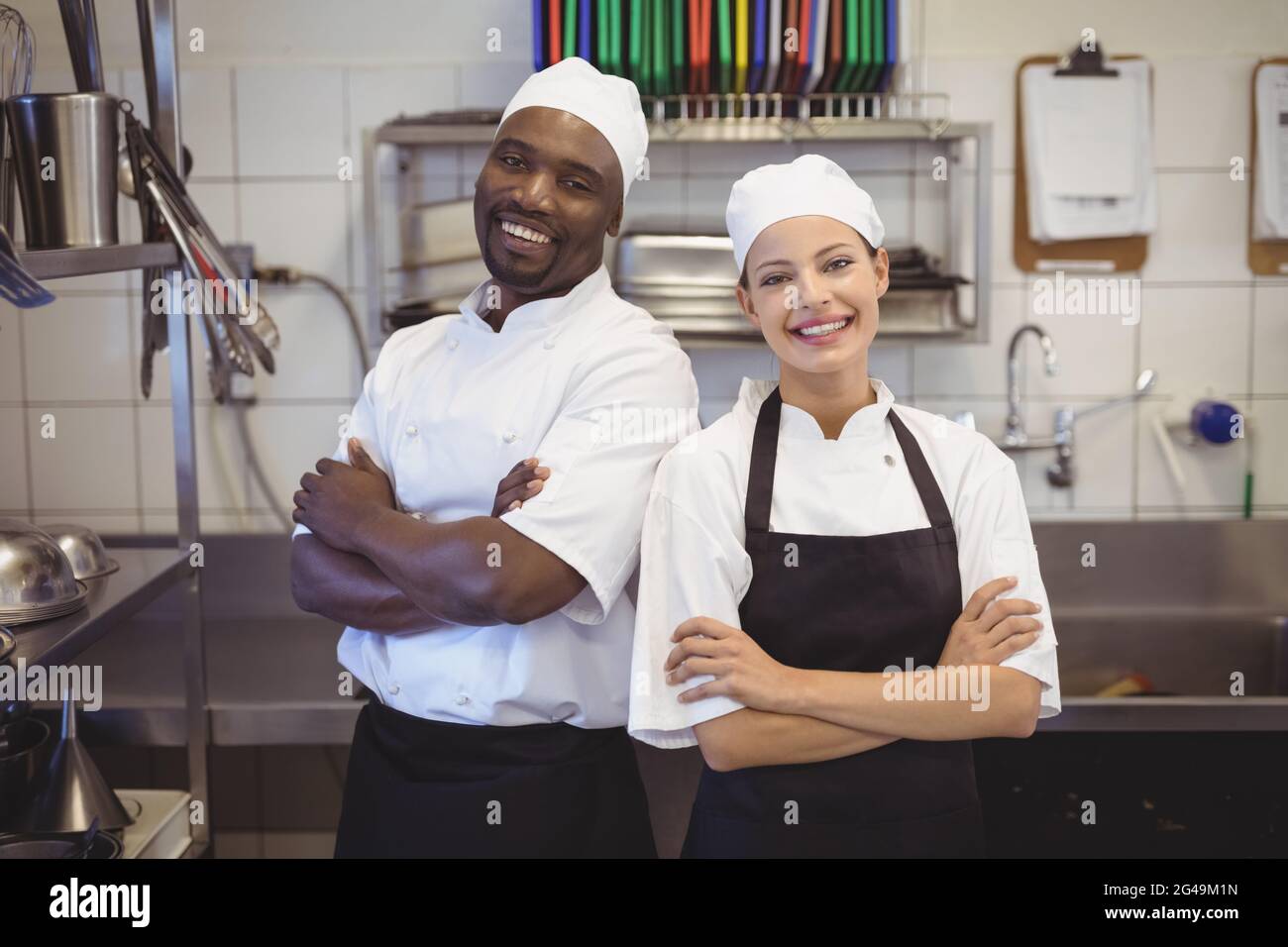 Two chefs standing with arms crossed in the commercial kitchen Stock ...