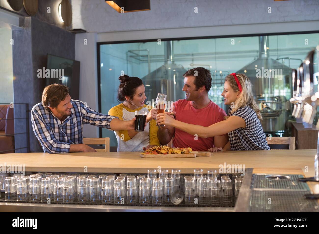 Happy friends toasting drinks at bar counter Stock Photo - Alamy