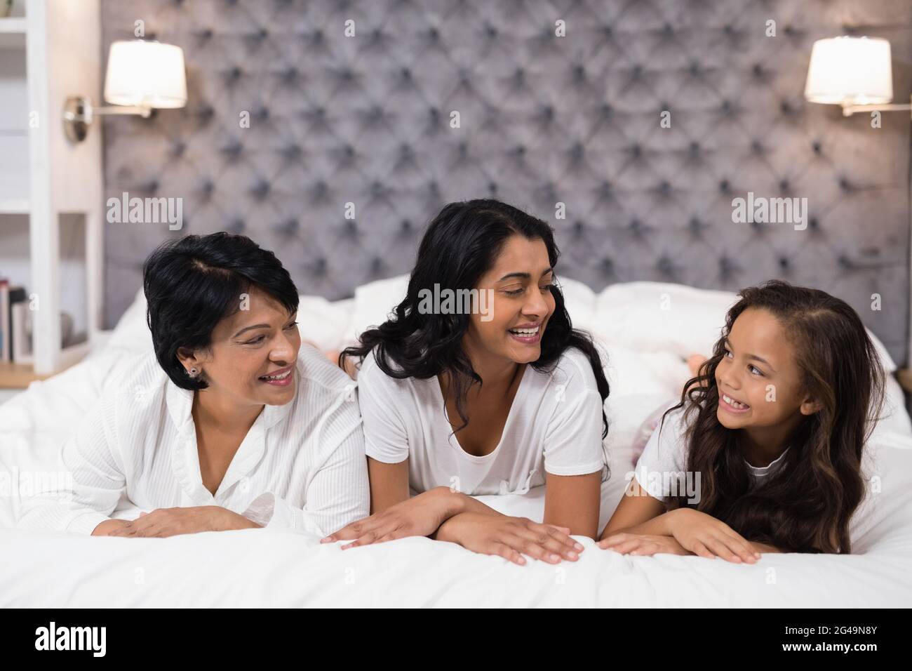 Cheerful multi-generation family lying on bed Stock Photo - Alamy