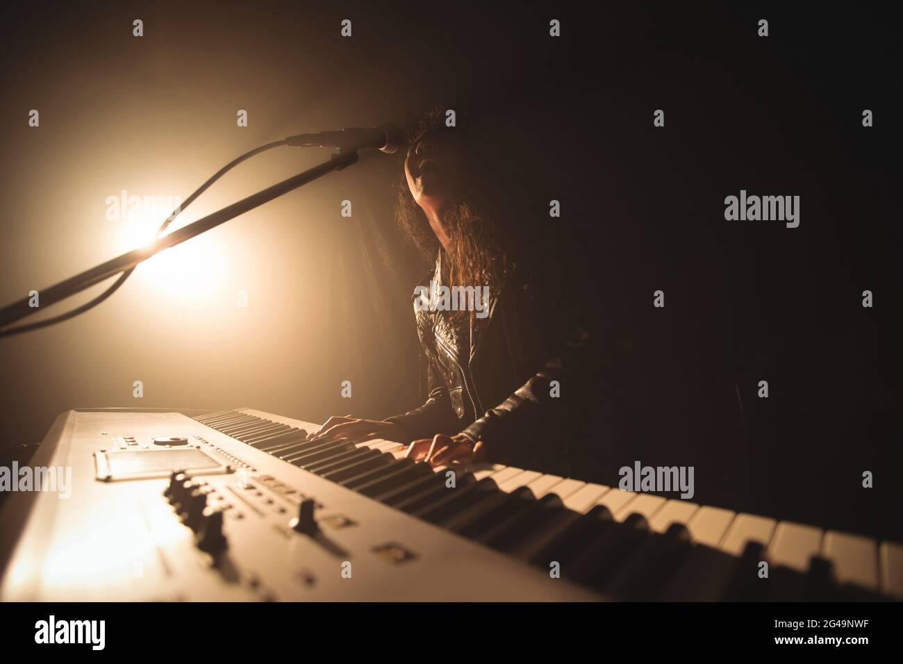 Female singer playing piano while performing in music concert Stock ...