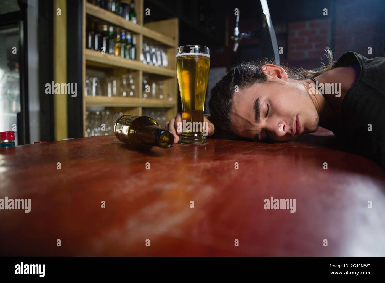 Man sleeping on bar counter Stock Photo - Alamy