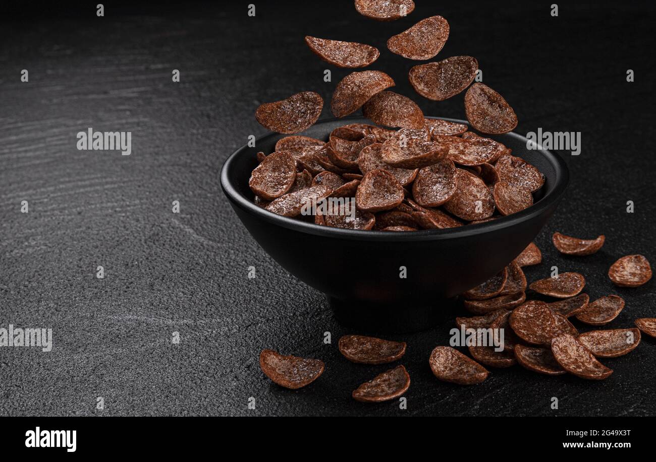 Falling chocolate corn flakes on black background Stock Photo - Alamy